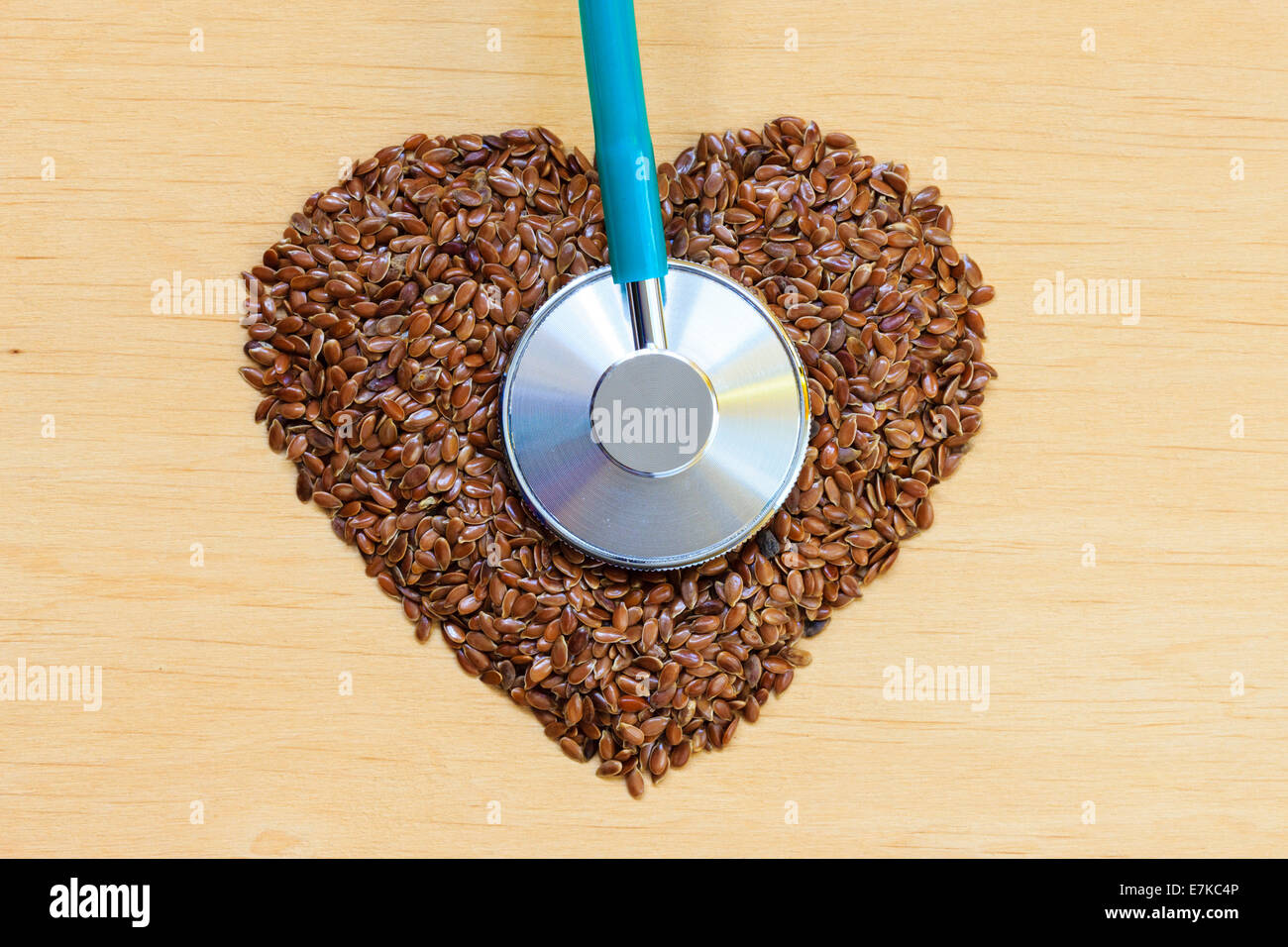 Diet healthcare and checkup concept. Raw flax seeds linseed heart shaped and stethoscope ...