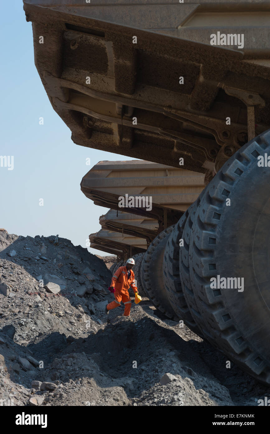 A mine worker inspects the tyres of his haul truck at the start of his ...