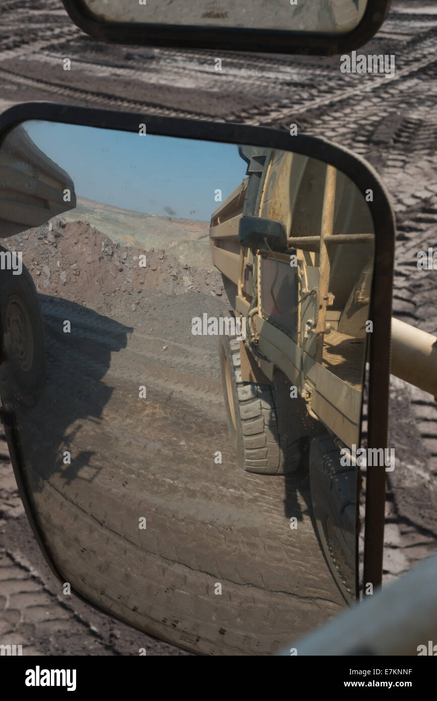 An operator's side mirror view from the cab of a massive Hitatchi ...