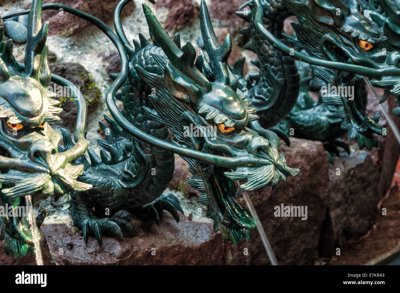Water flows from a series of dragon heads into a pool at Hakone shrine ...