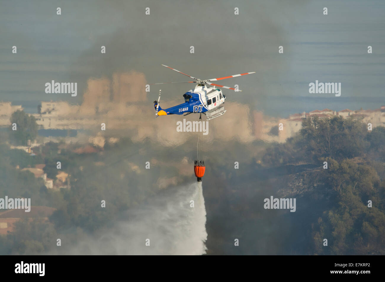 Aerial Firefighting with helicopter water bombing a bushfire near an ...