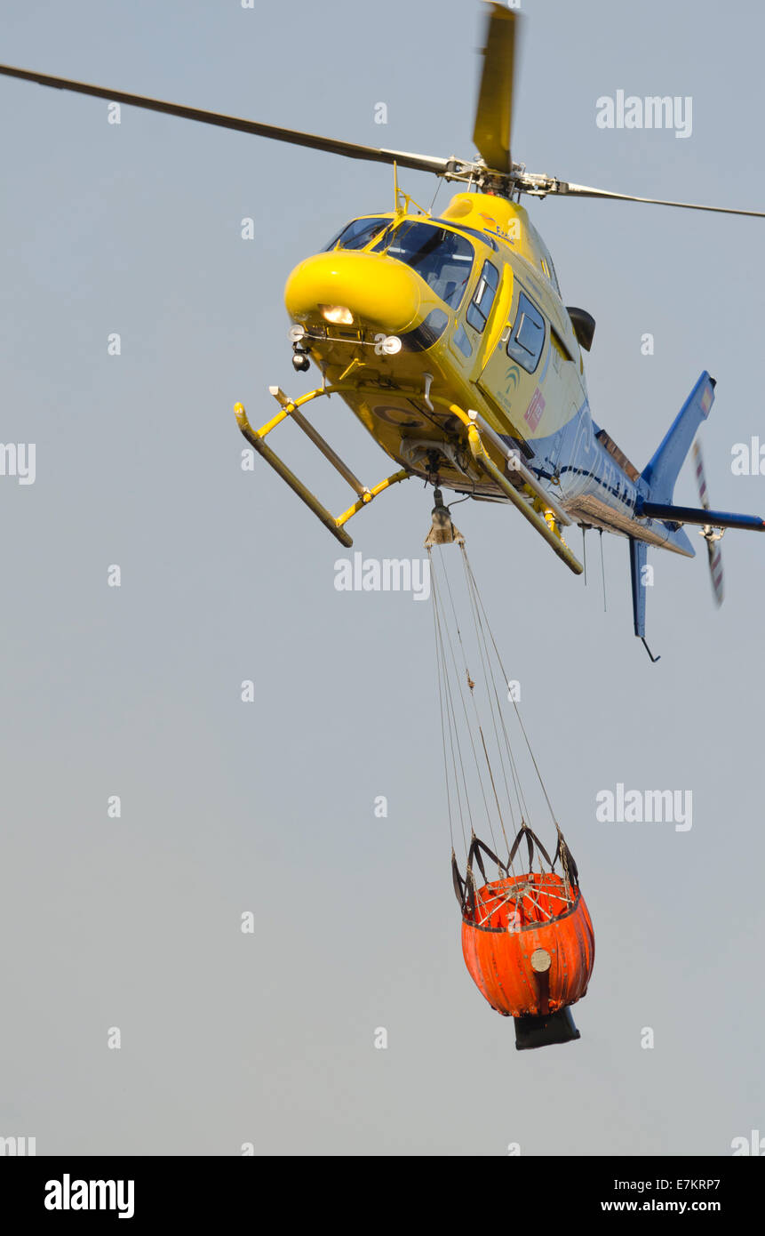 Aerial Firefighting with helicopter water bombing a bushfire near an ...
