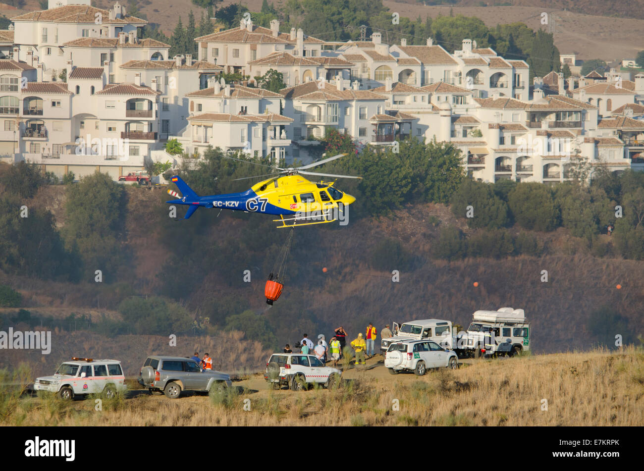 Aerial Firefighting with helicopter water bombing a bushfire near an ...