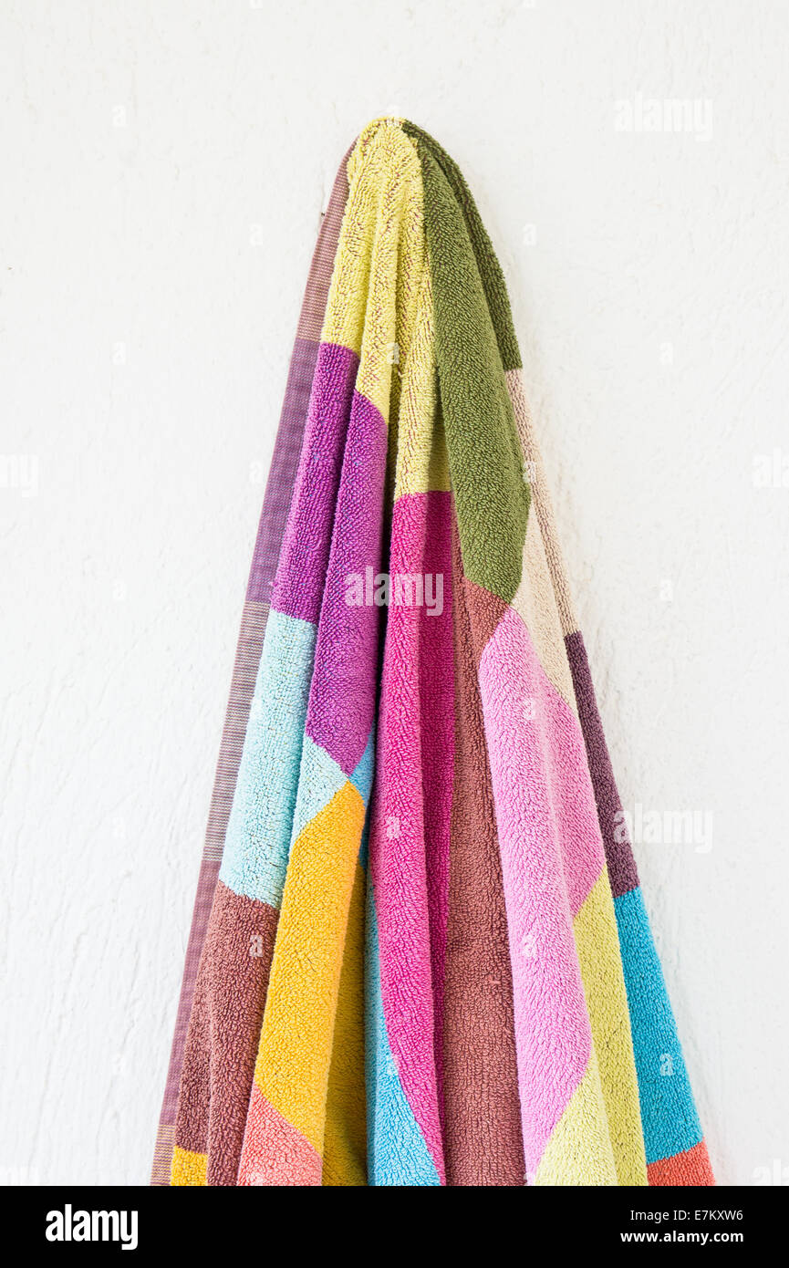 A colorful towel hanging on a white wall Stock Photo - Alamy