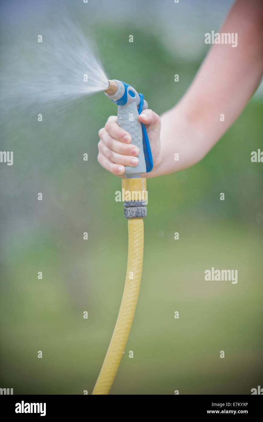Summer fun with a girl and a hose water wet spray Stock Photo - Alamy