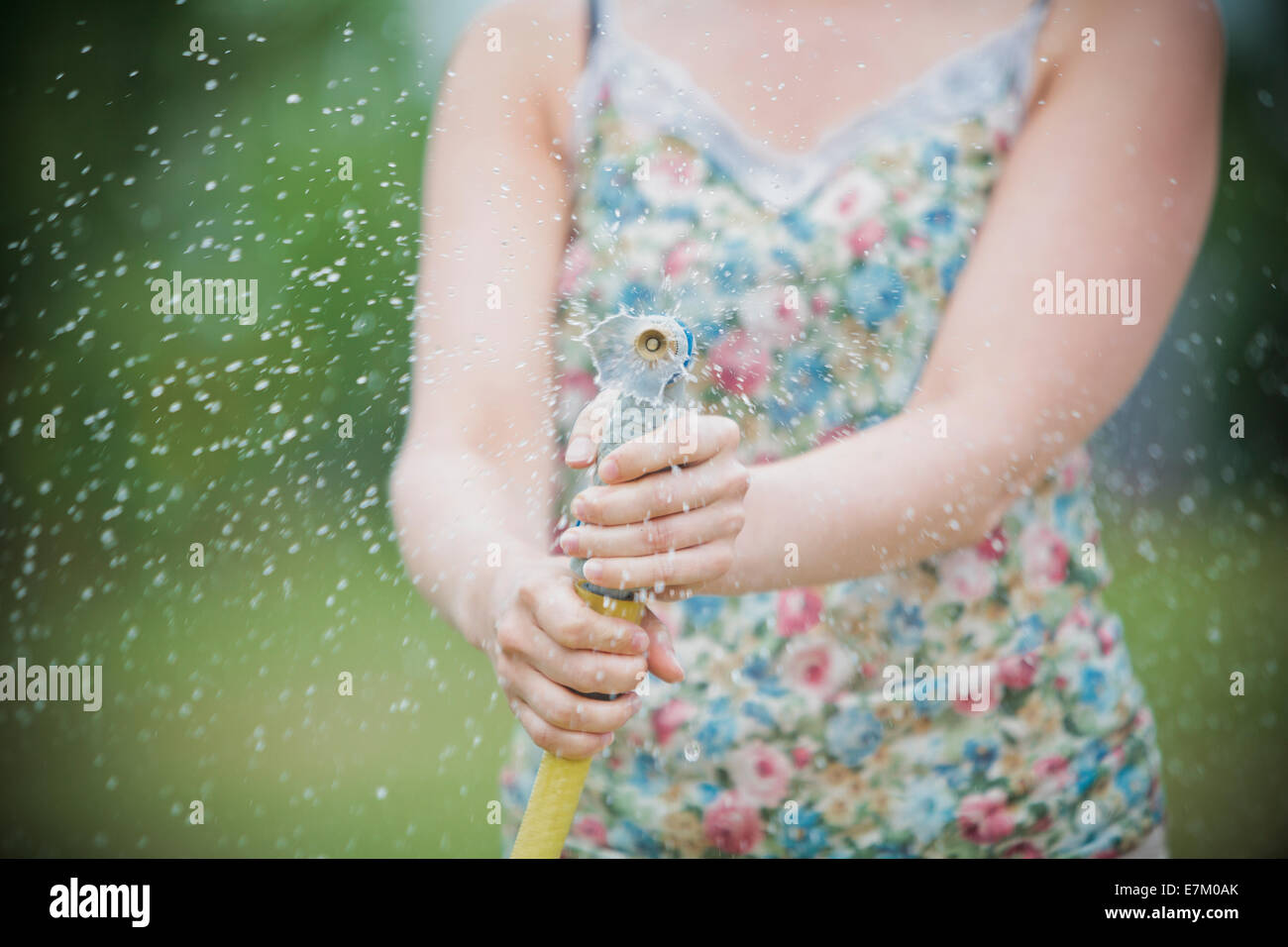 Summer fun with a girl and a hose water wet spray Stock Photo - Alamy