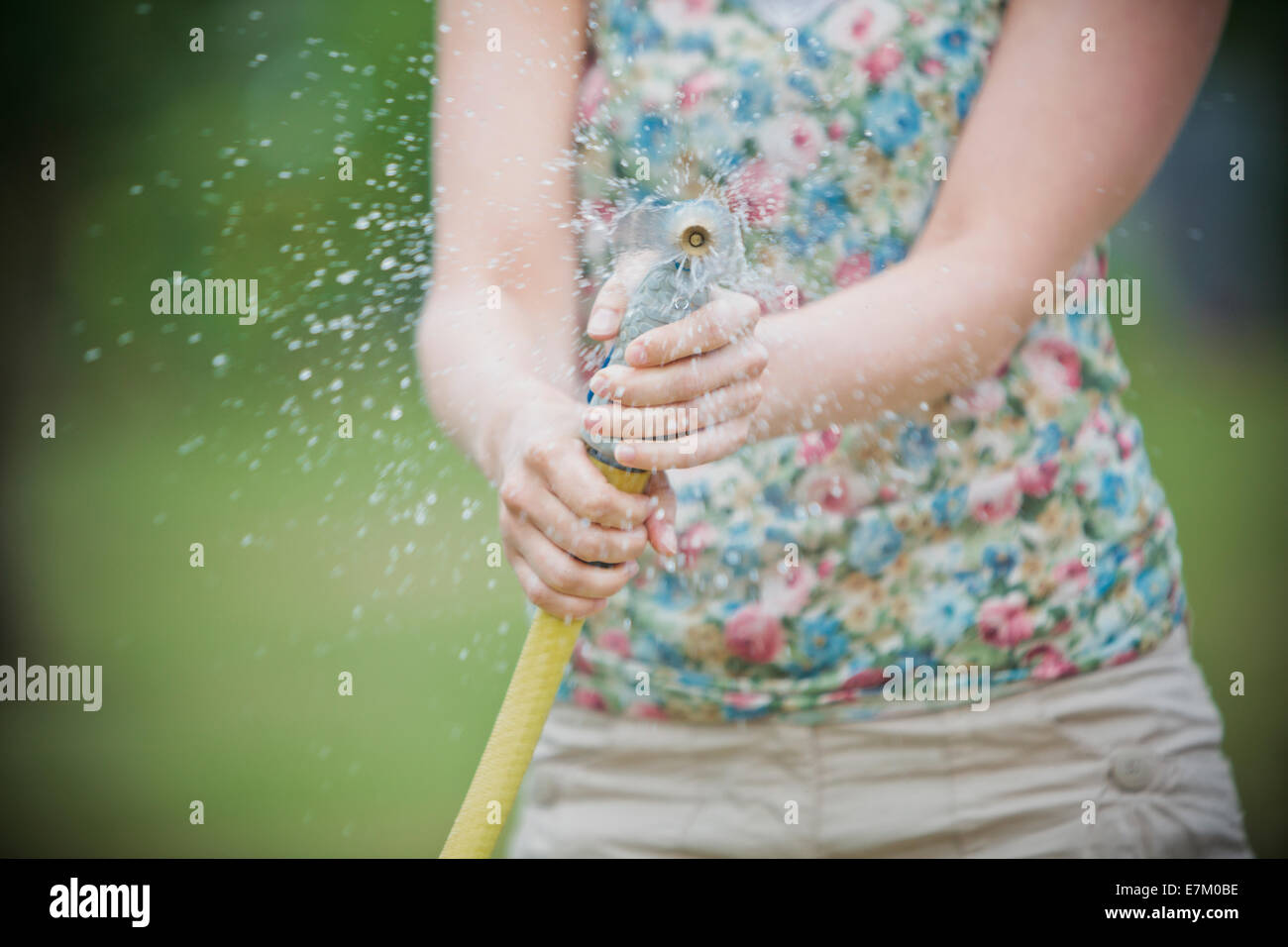 Summer fun with a girl and a hose water wet spray Stock Photo - Alamy