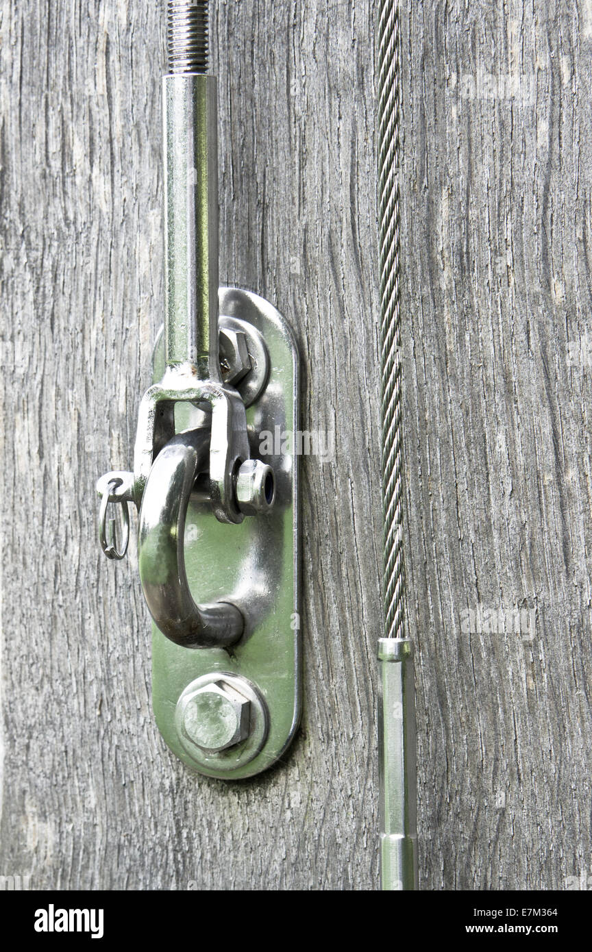 Wire cable fastened to a ring on a wooden structure Stock Photo - Alamy
