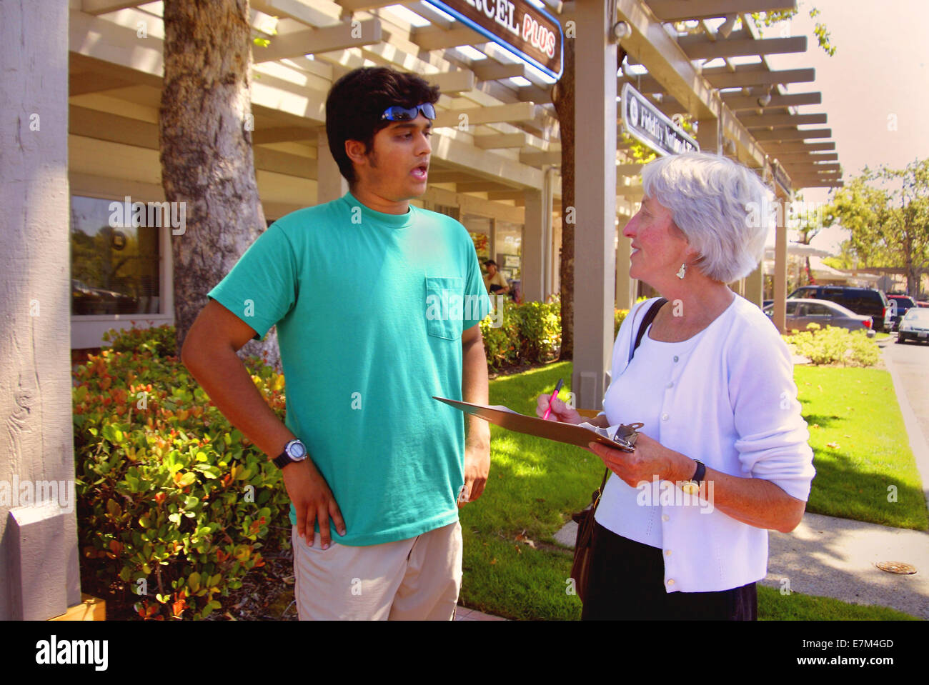 Conducting a consumer survey, a woman interviews a teenager in a ...
