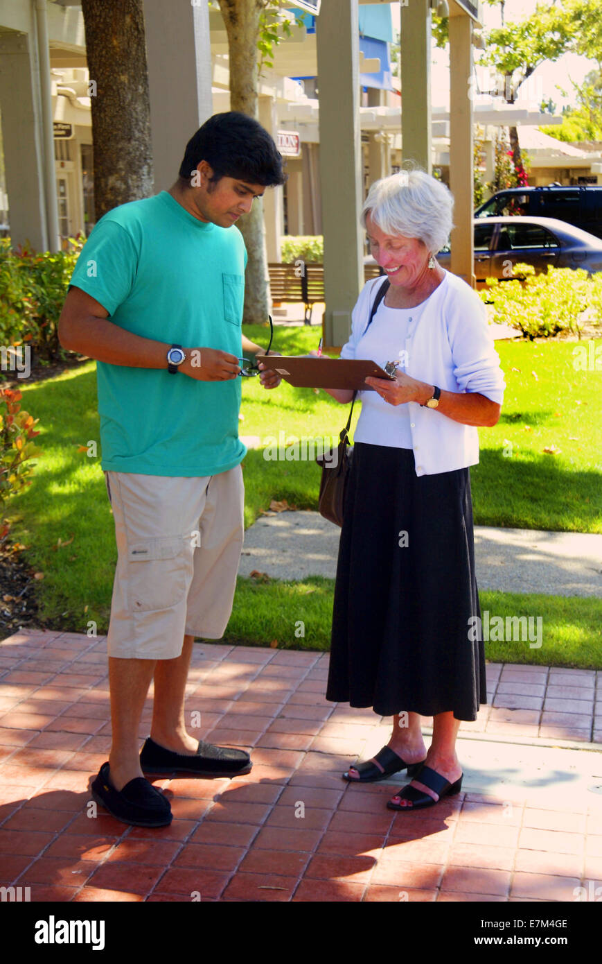 Conducting a consumer survey, a woman interviews a teenager in a ...
