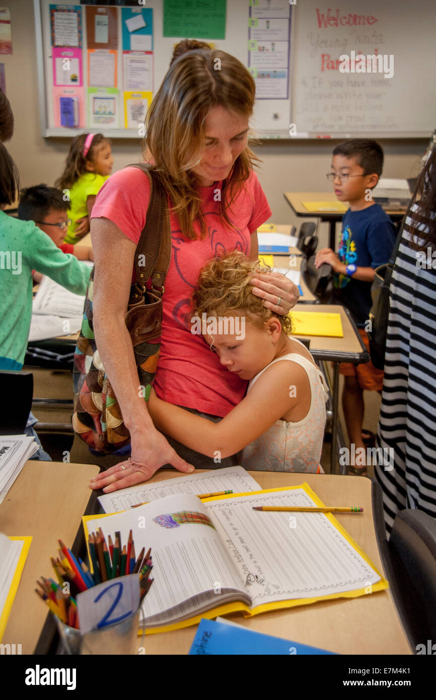 A mother hugs her frightened daughter in an elementary school Parent's ...