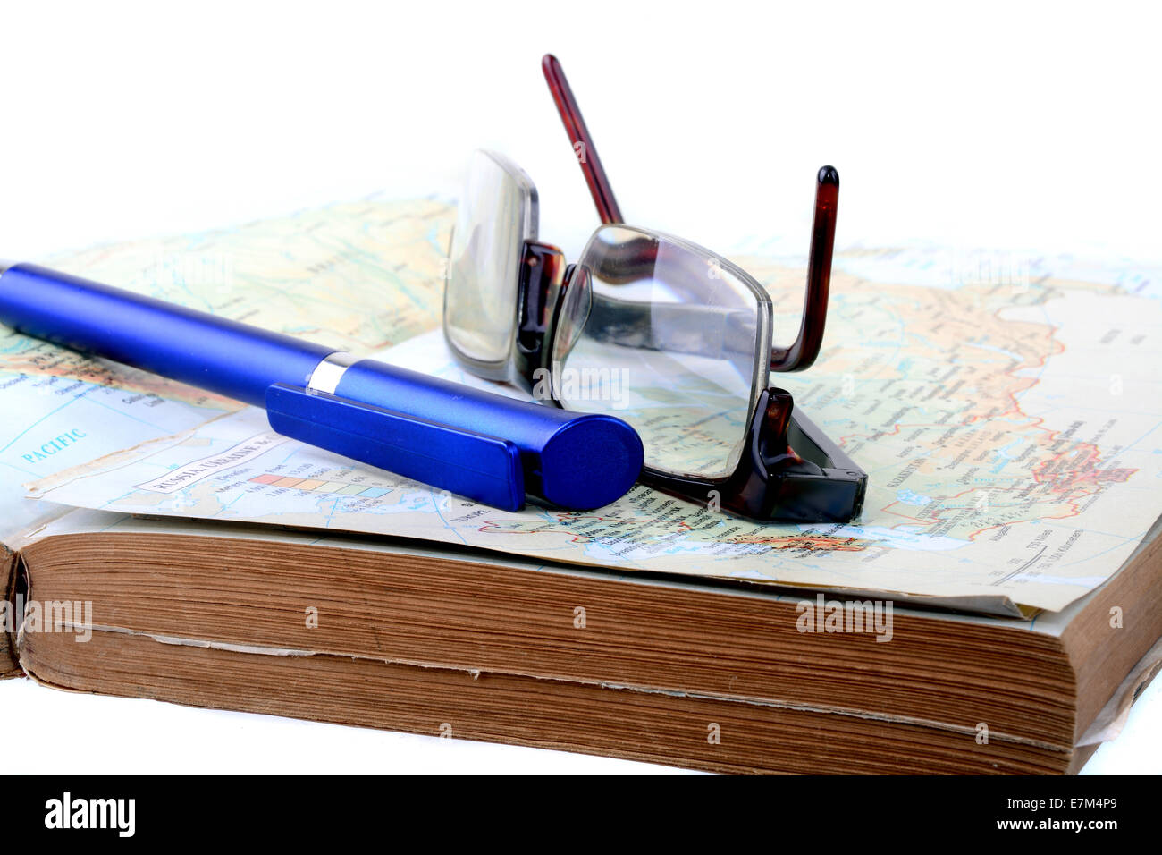 Reading glasses over a book with a blue pen Stock Photo - Alamy