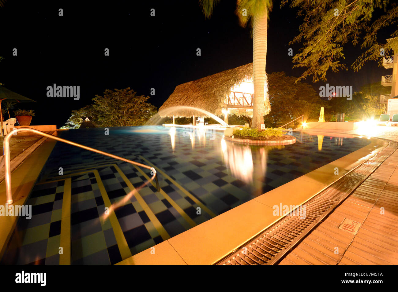 Swimming pool area illuminated at evening time Stock Photo - Alamy