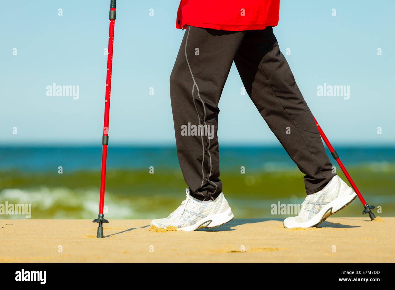Nordic walking. Closeup of female legs hiking on the beach. Active and ...