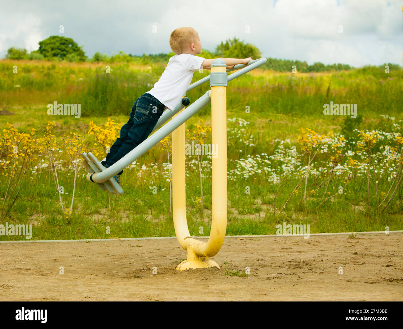Child in playground kid in action boy playing on stretching equipment ...