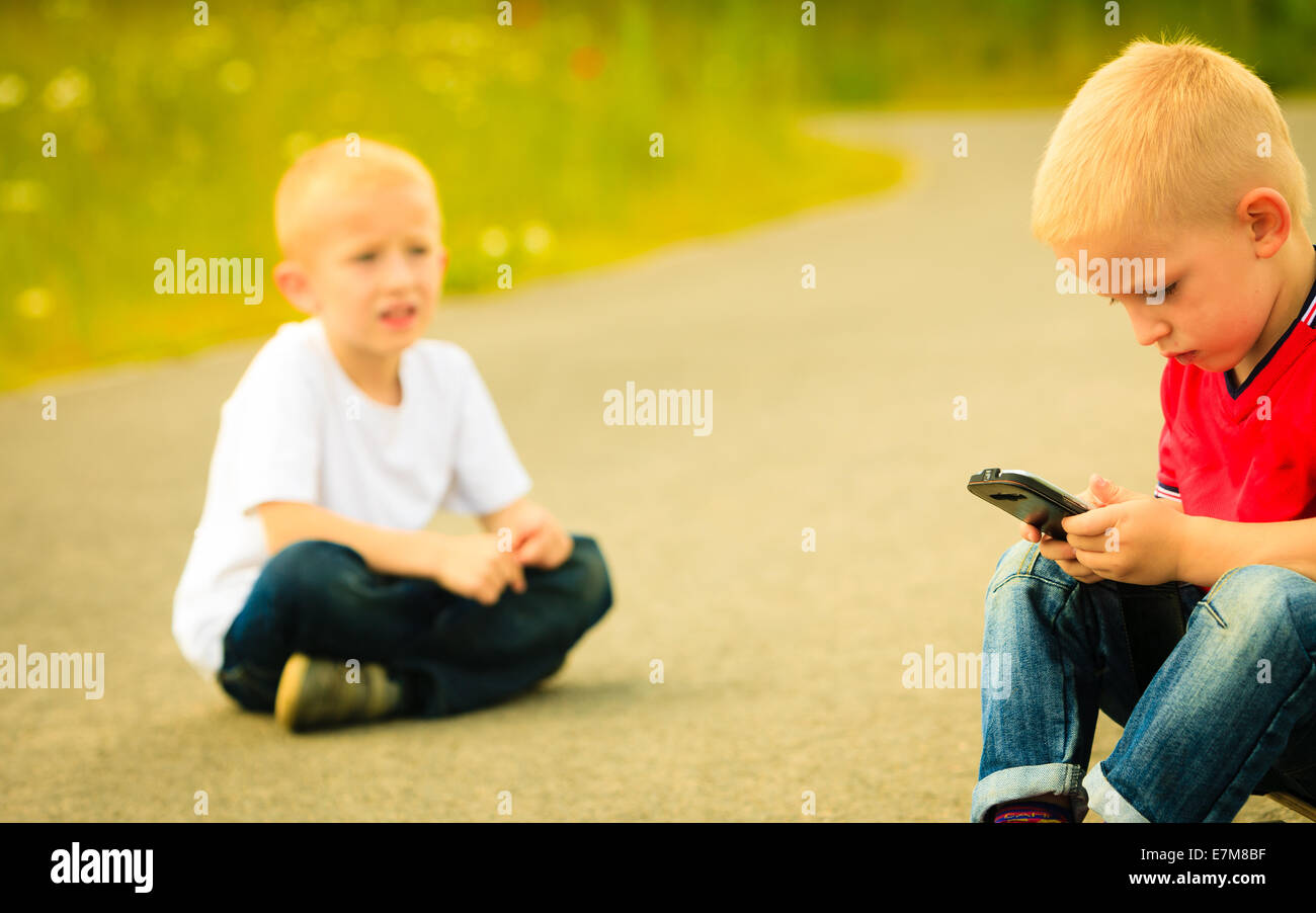 Little boy child kid playing games on smartphone mobile phone outdoor ...