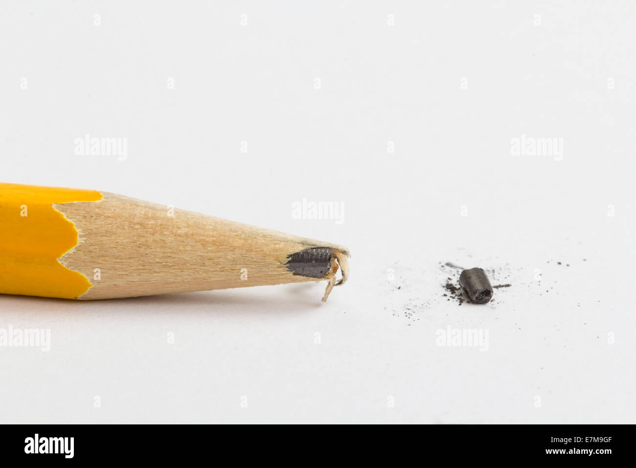 Yellow pencil over a blank sheet of paper with a broken tip. Focus on ...
