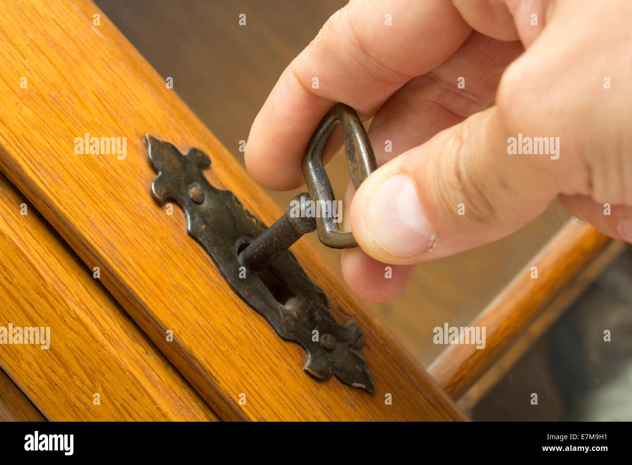The man hand, locking a key from a wood door Stock Photo - Alamy