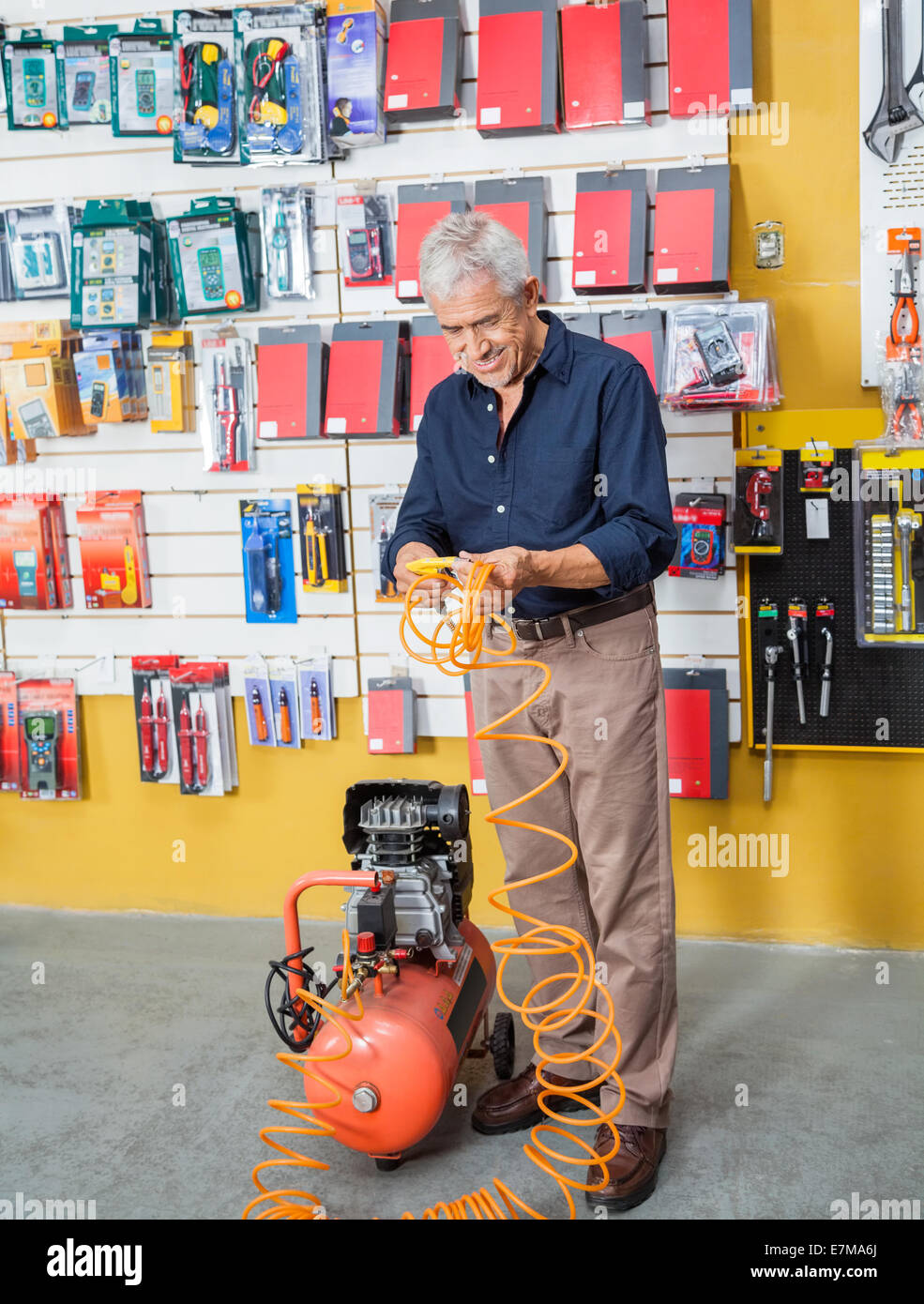 Senior Man Examining Air Compressor In Store Stock Photo - Alamy