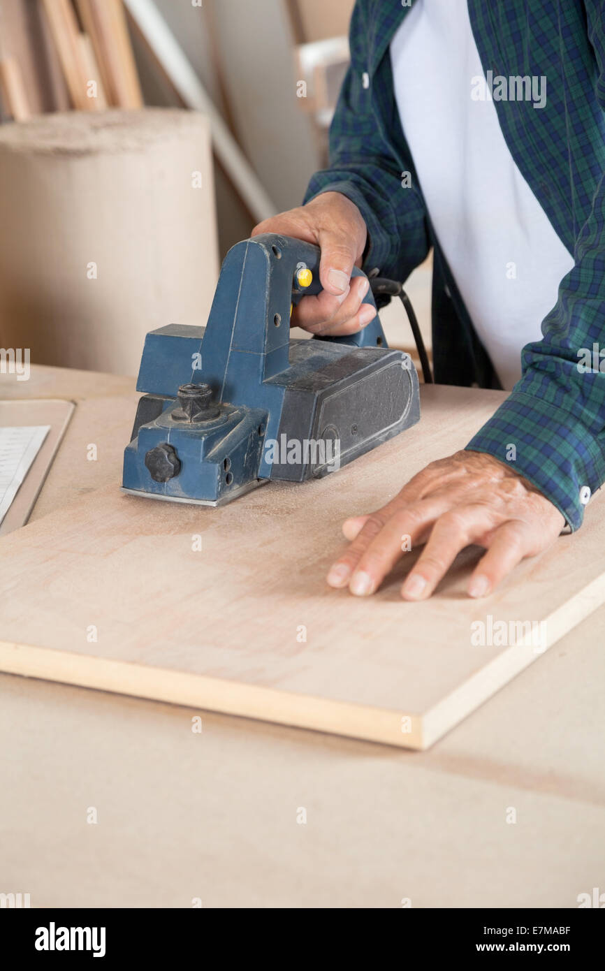 Carpenter Using Electric Planer On Wood Stock Photo - Alamy