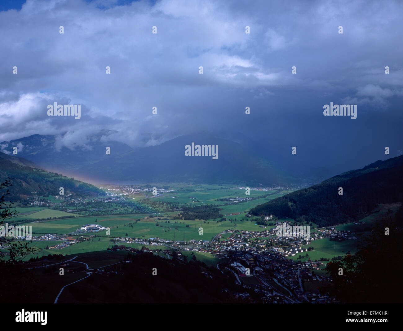 Storm clouds and rainbow passing over the village of Schuttdorf in the ...