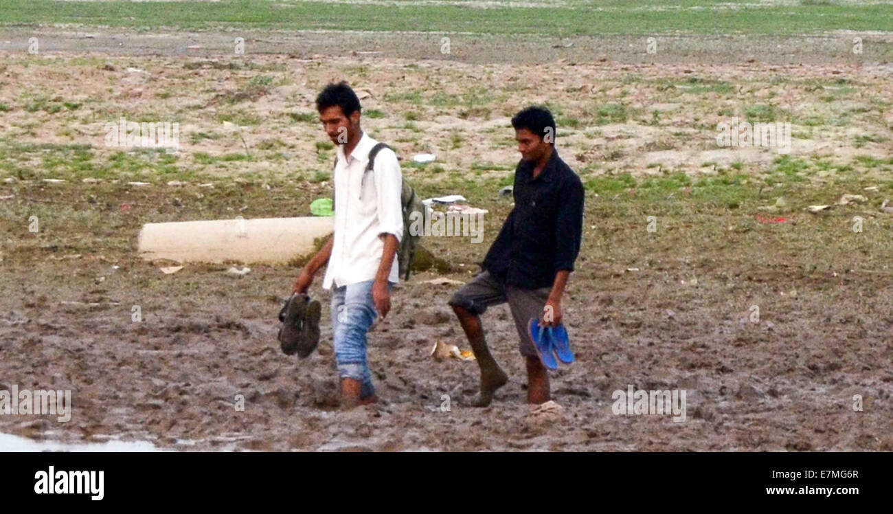 Indian walks over mud on the banks of a river after waters from the ...