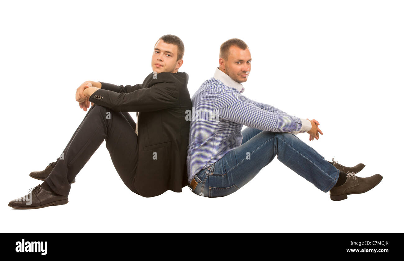 Two Men Sitting Back to Back Looking at Camera in Studio with White ...