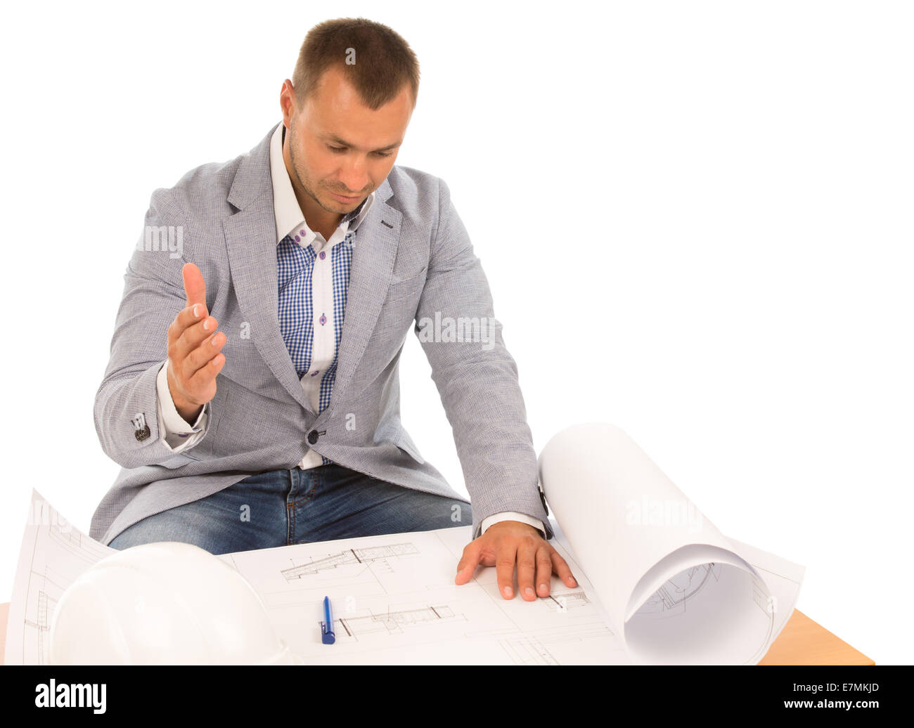 Puzzled architect looking at a building plan grimacing and raising his ...