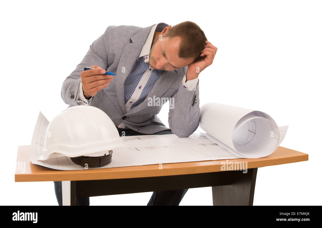 Architect solving a problem on a building plan sitting at a small ...