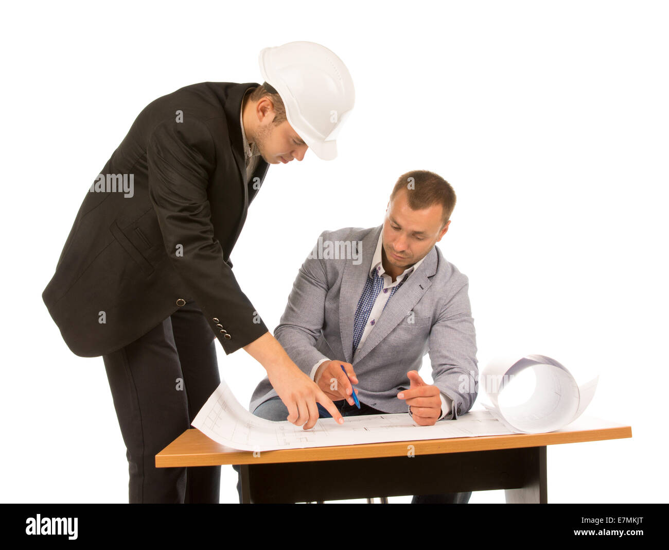 Two building contractors discussing a blueprint of a project they are ...