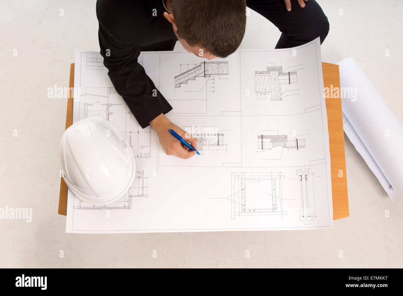 View from above of an architect drafting or modifying a building plan ...