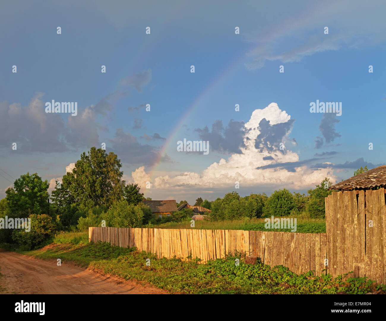 Rainbow over village Stock Photo - Alamy
