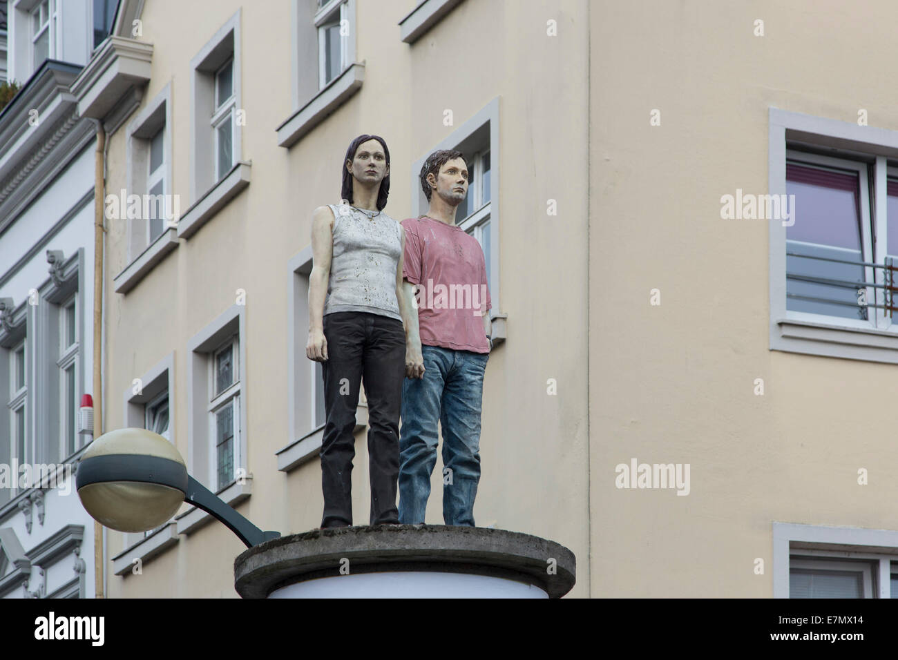 Statue of a young couple holding hands on an advertising pillar in ...