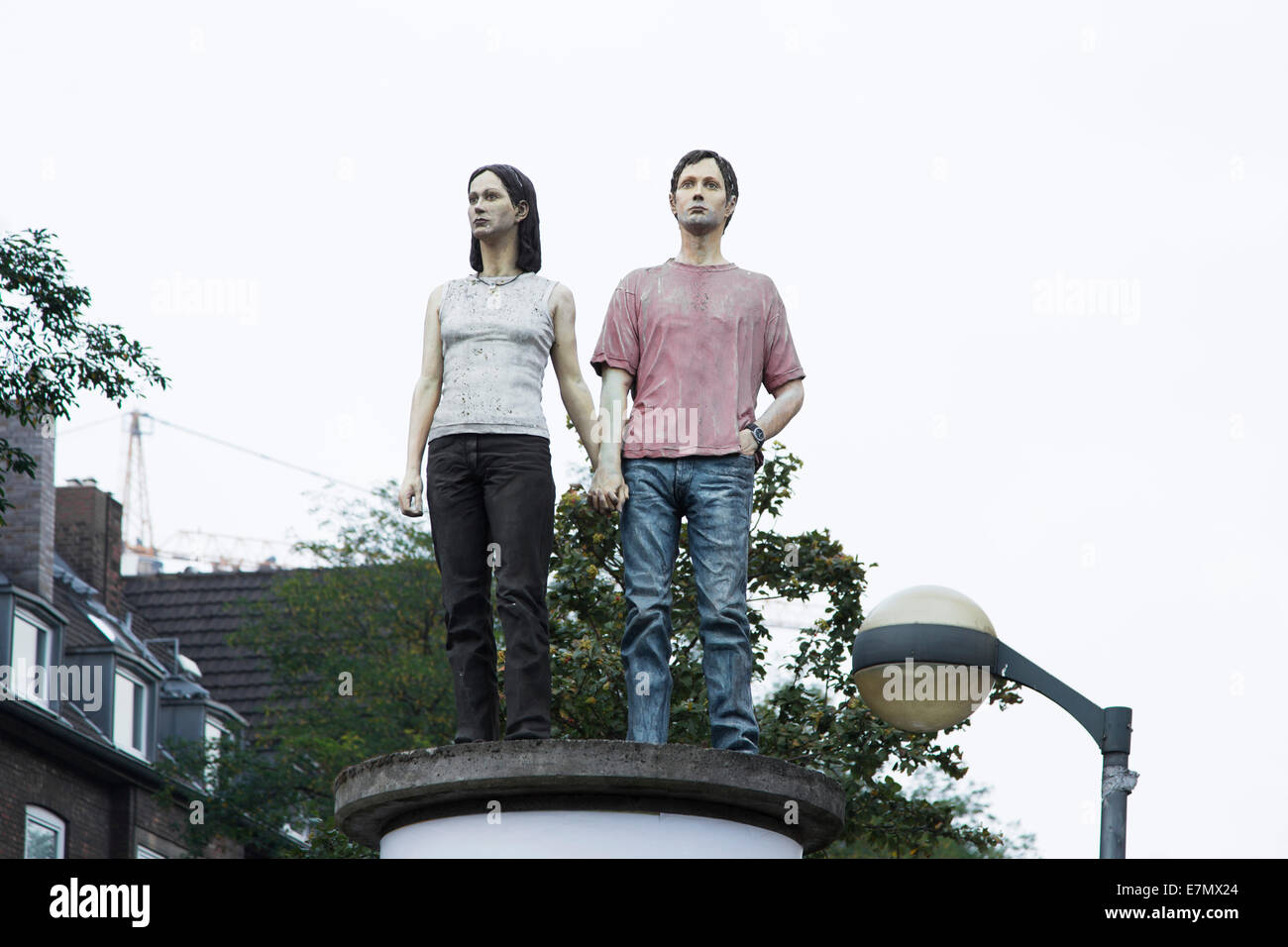 Statue of a young couple holding hands on an advertising pillar in ...