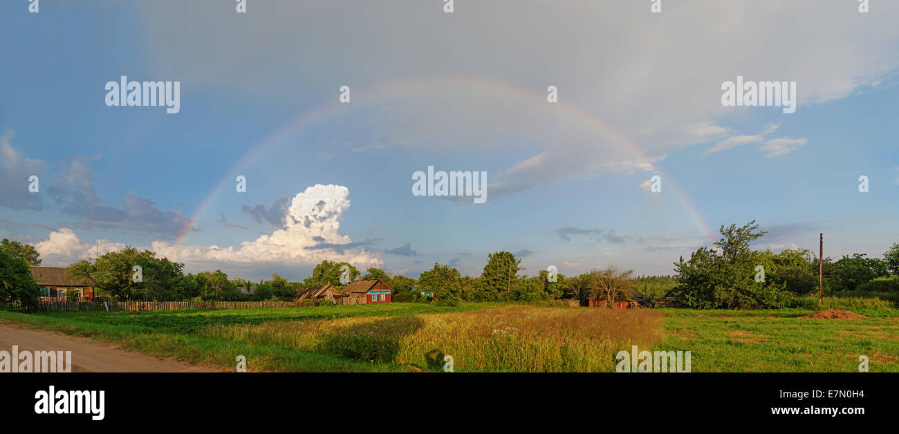 Rainbow gate over village Stock Photo - Alamy