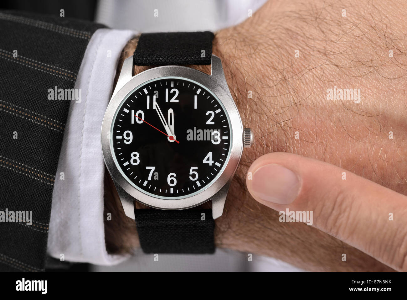 Businessman pointing at wristwatch Stock Photo - Alamy