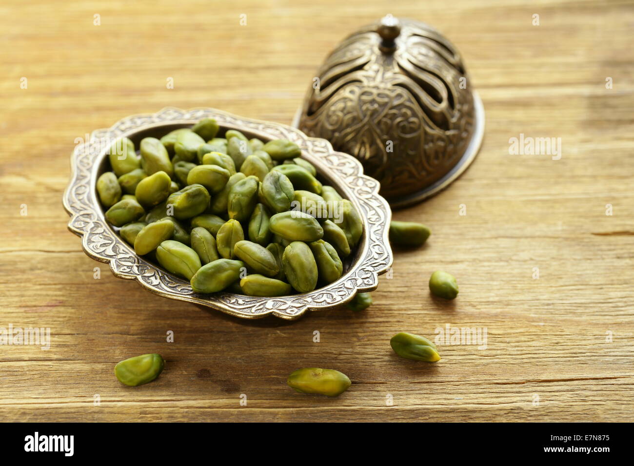 peeled green pistachio nuts on a wooden background Stock Photo - Alamy