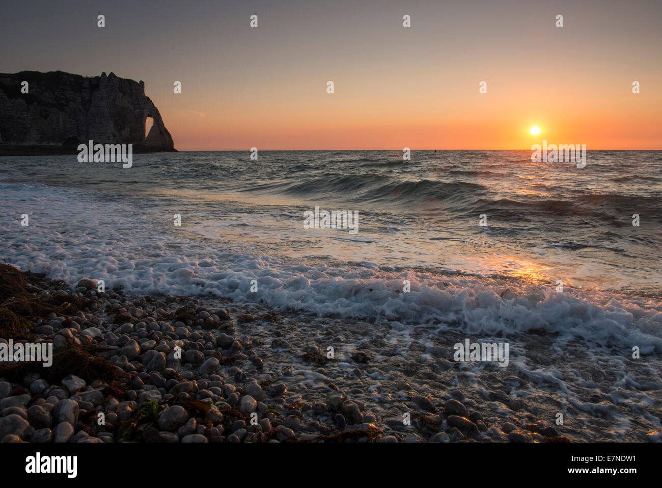 Sunset on the beach at Etratat on the coast of Normandy in Northern ...