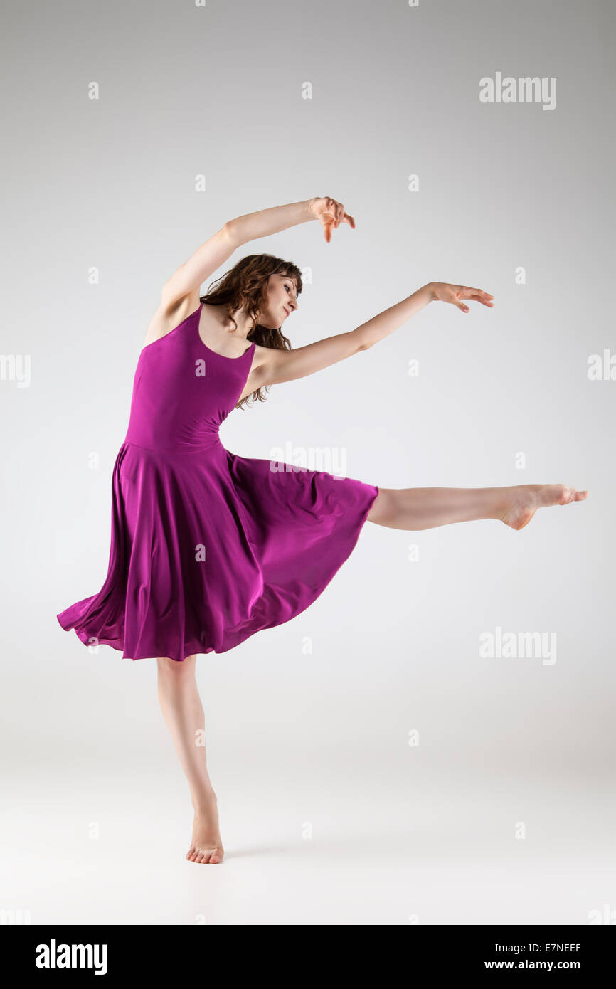 Young ballet dancer wearing purple dress over grey Stock Photo - Alamy