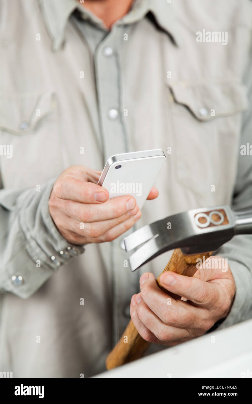 Man Scanning Hammer Through Smartphone Stock Photo - Alamy