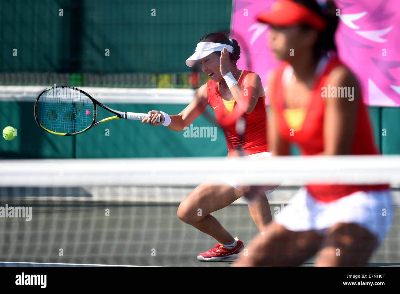 Incheon, South Korea. 22nd Sep, 2014. Zheng Jie (back) of China returns ...
