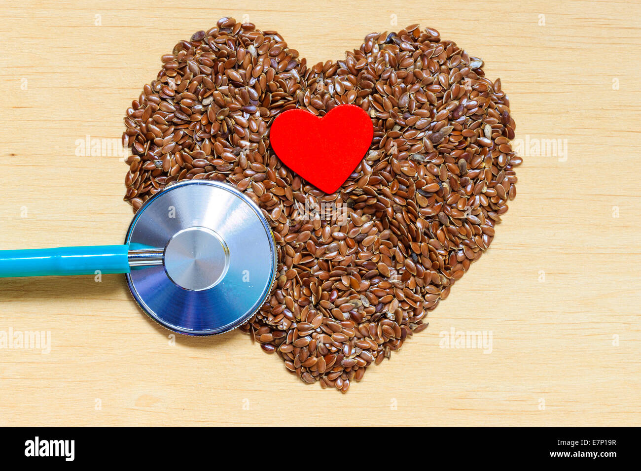 Diet healthcare and checkup concept. Raw flax seeds linseed heart shaped and stethoscope ...