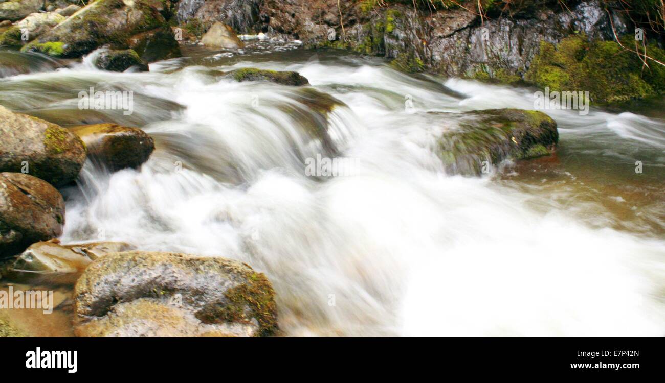 Fast flowing river over rocks showing a slow motion flow of the water ...