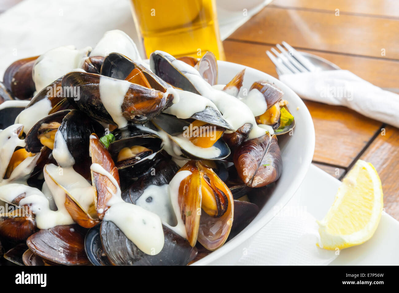 Plate full of mussels with garlic sauce on the table in restaurant ...