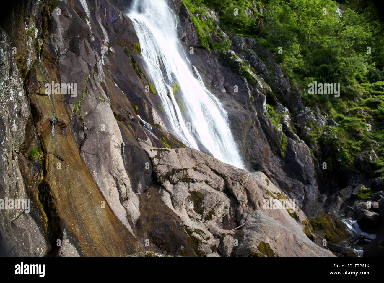 Waterfall over rocks with trees to the side Stock Photo - Alamy