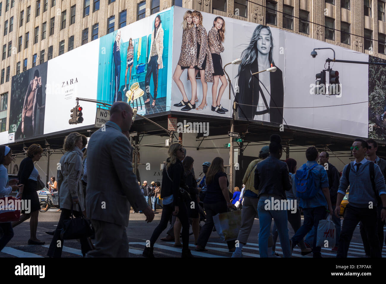 Pedestrians cross 42nd street in New York past a billboard advertising ...