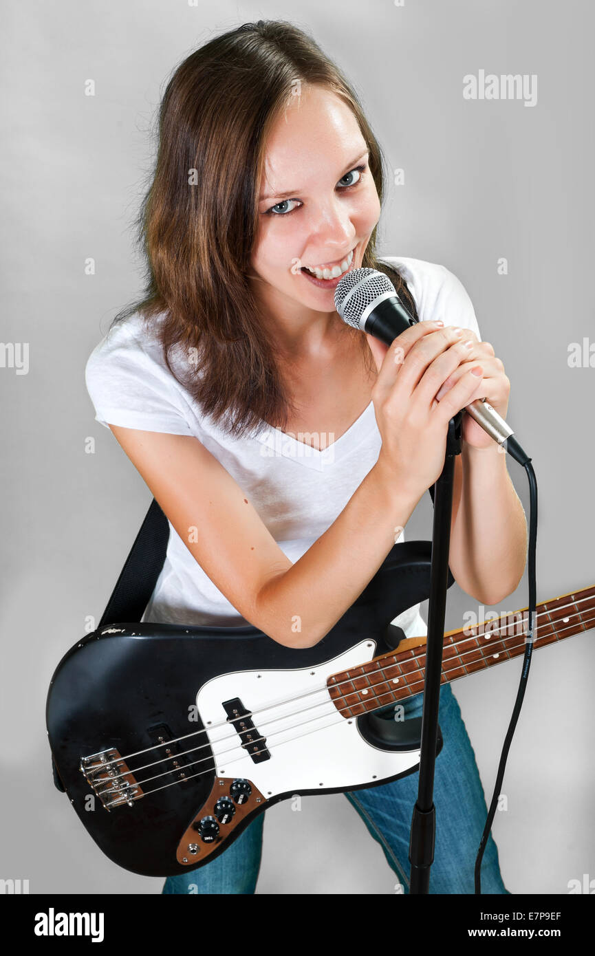 Girl with bass guitar and microphone isolated on gray background Stock ...