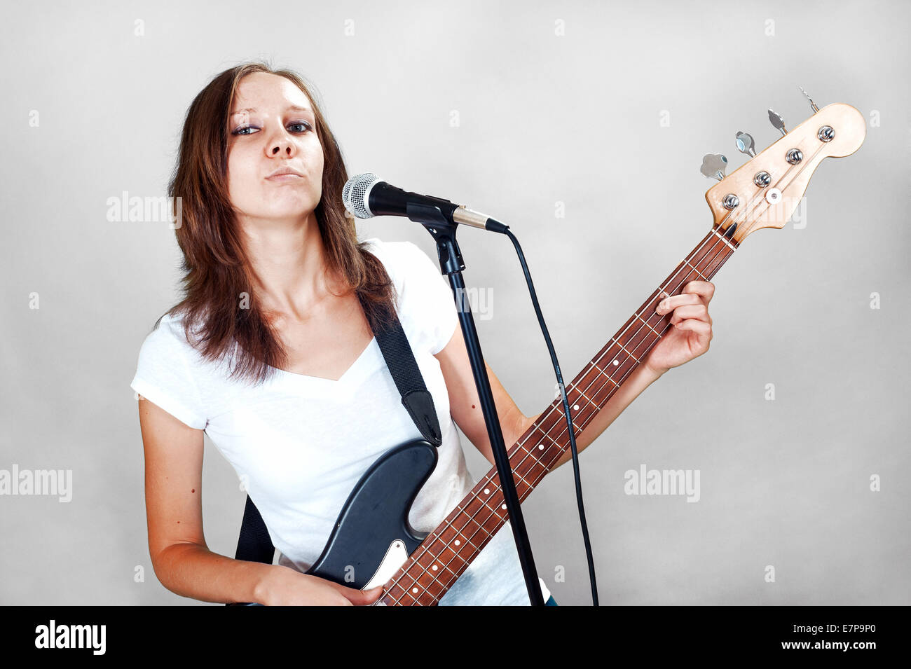Girl with bass guitar and microphone isolated on gray background Stock ...