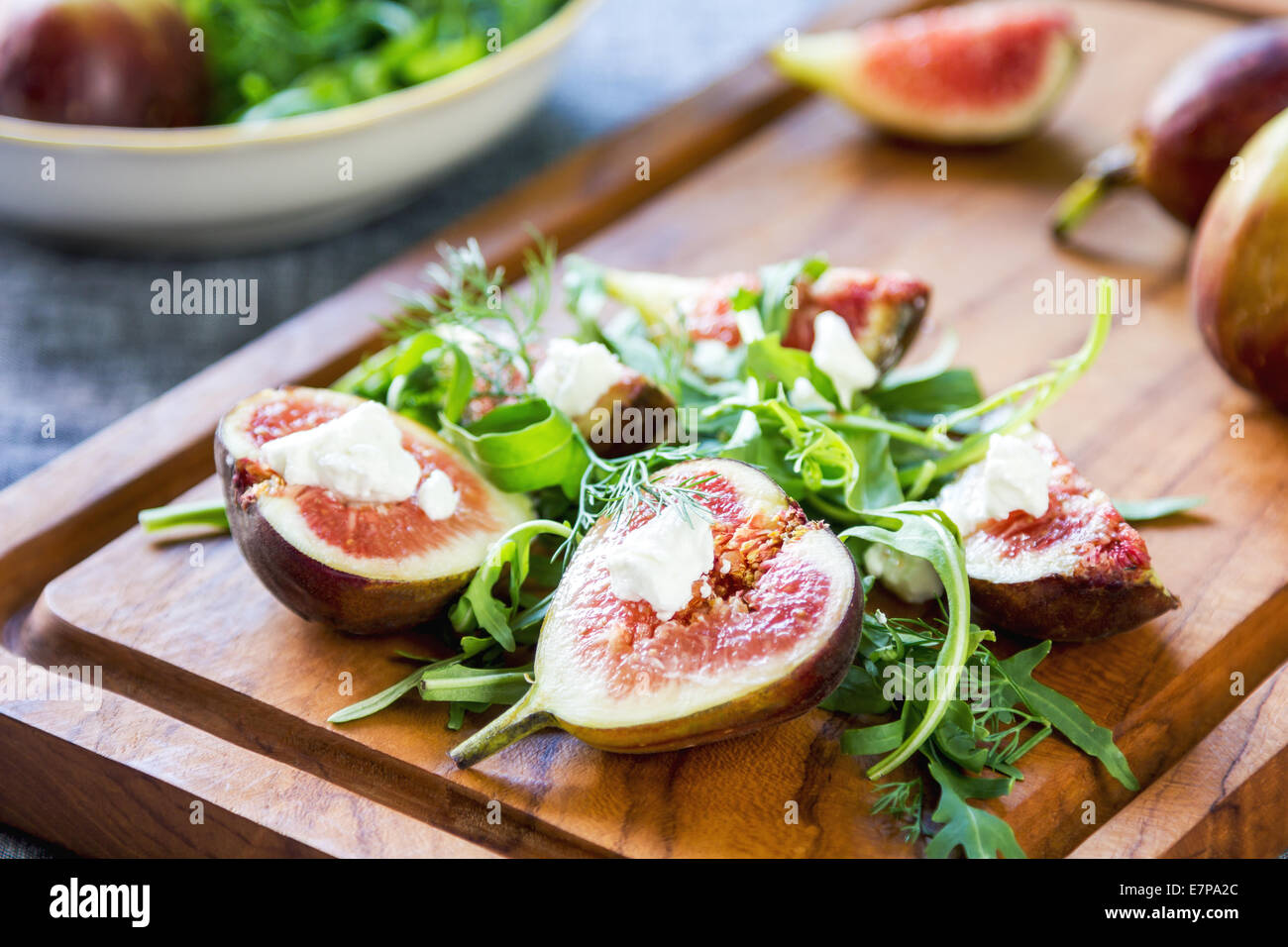 Fig with Goat cheese and Rocket salad on wooden chopping board Stock ...