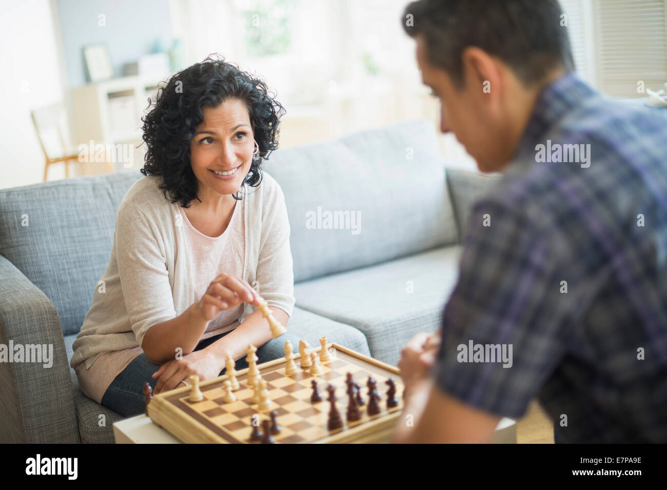 Couple playing chess in living room Stock Photo - Alamy